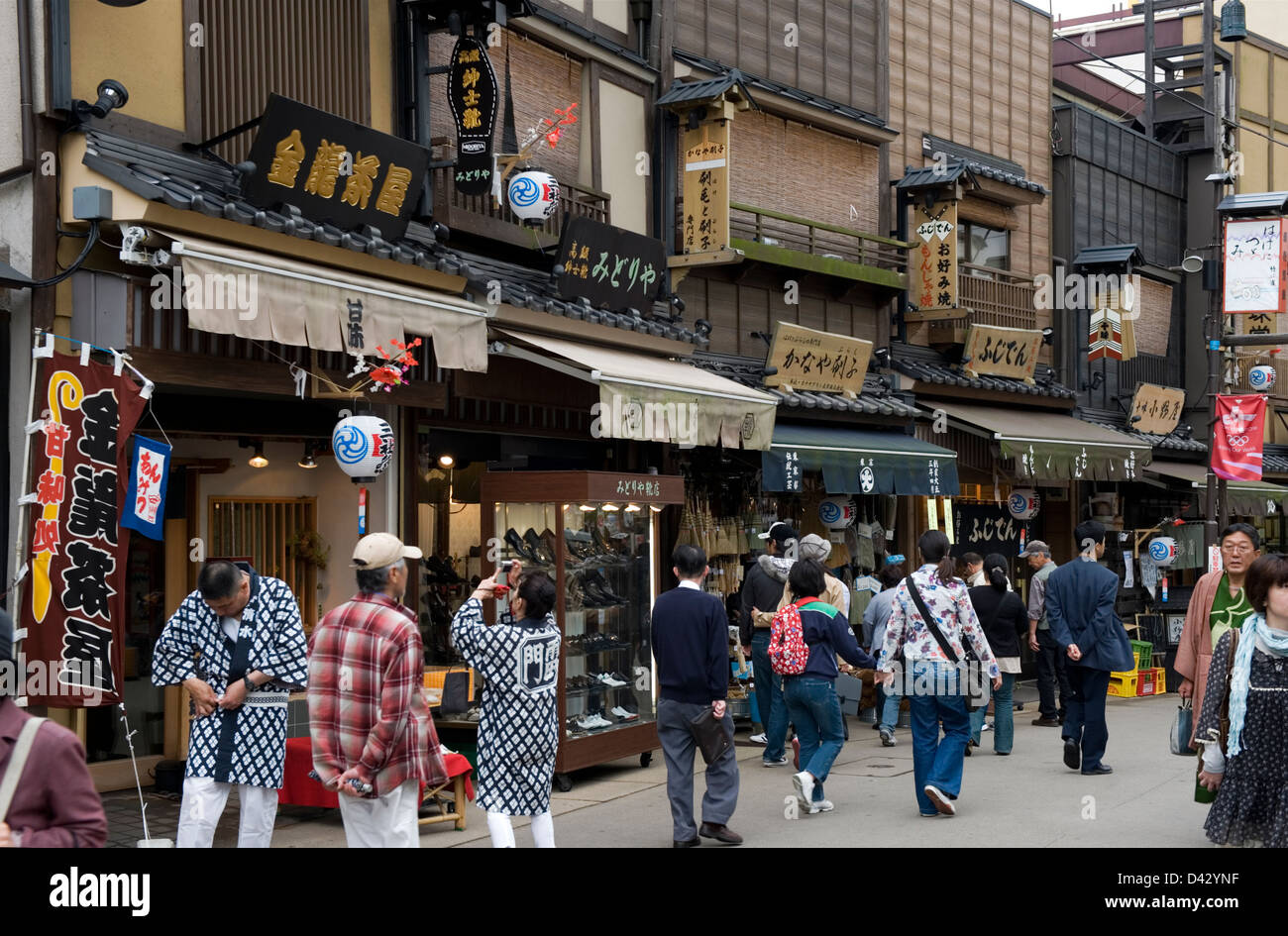 Tourists and shoppers strolling past recreated old-style shops in the ...