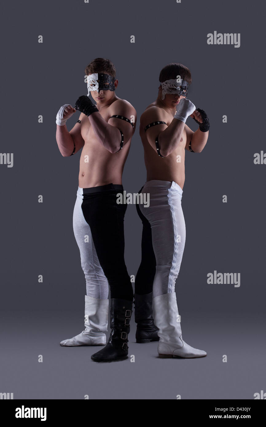 Two attractive men in masks posing and fight Stock Photo - Alamy