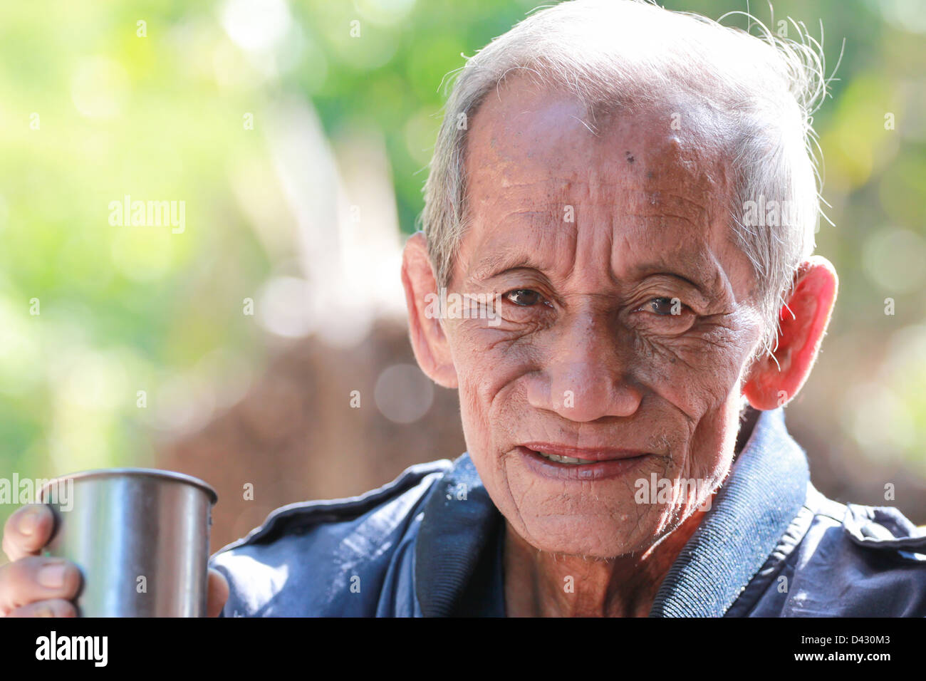 an aged cheerful old man holding a cup of coffee Stock Photo - Alamy