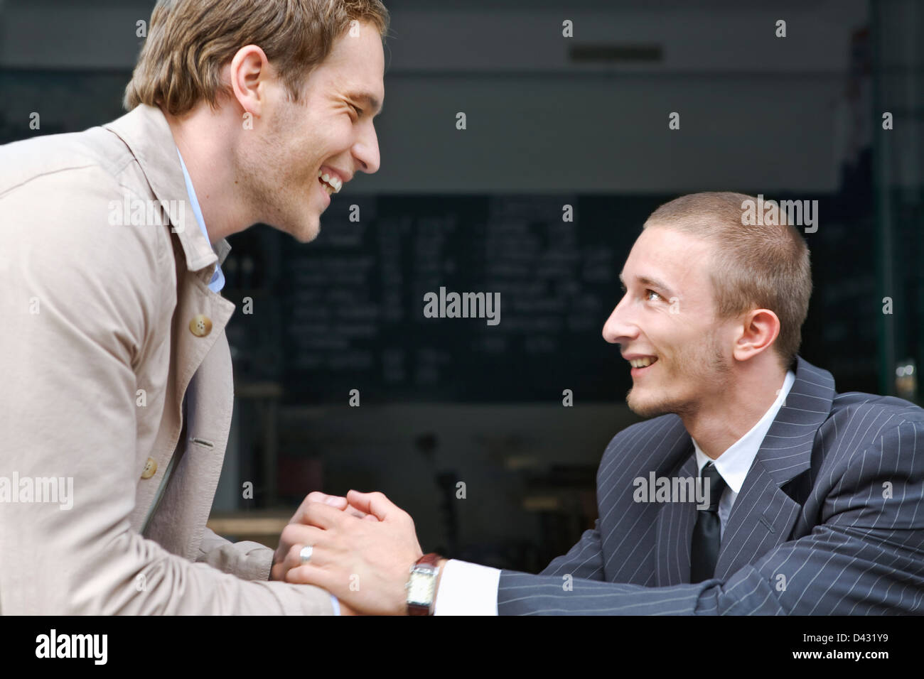 hearty greeting and handshake of friends meeting up after work. slight ...