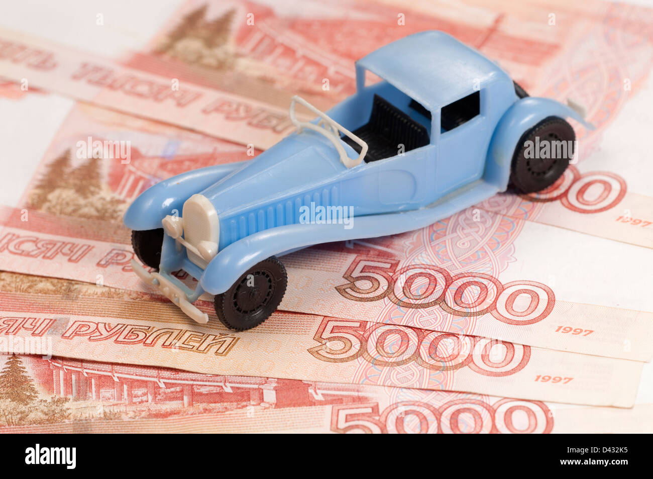 Toy car on a paper money - buying of a car concept Stock Photo - Alamy