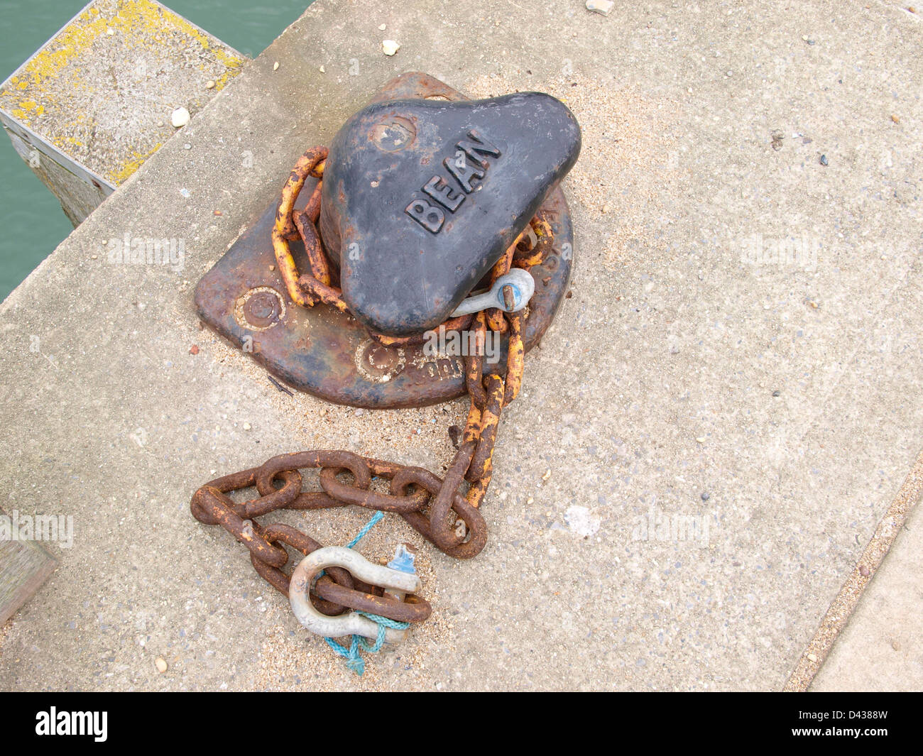 Capstan on quayside with short chain attached Stock Photo - Alamy