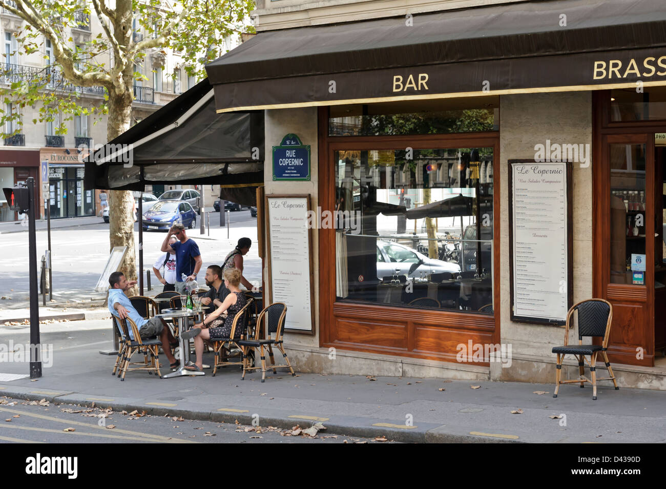 Three people sitting and having drinks outside a French restaurant ...