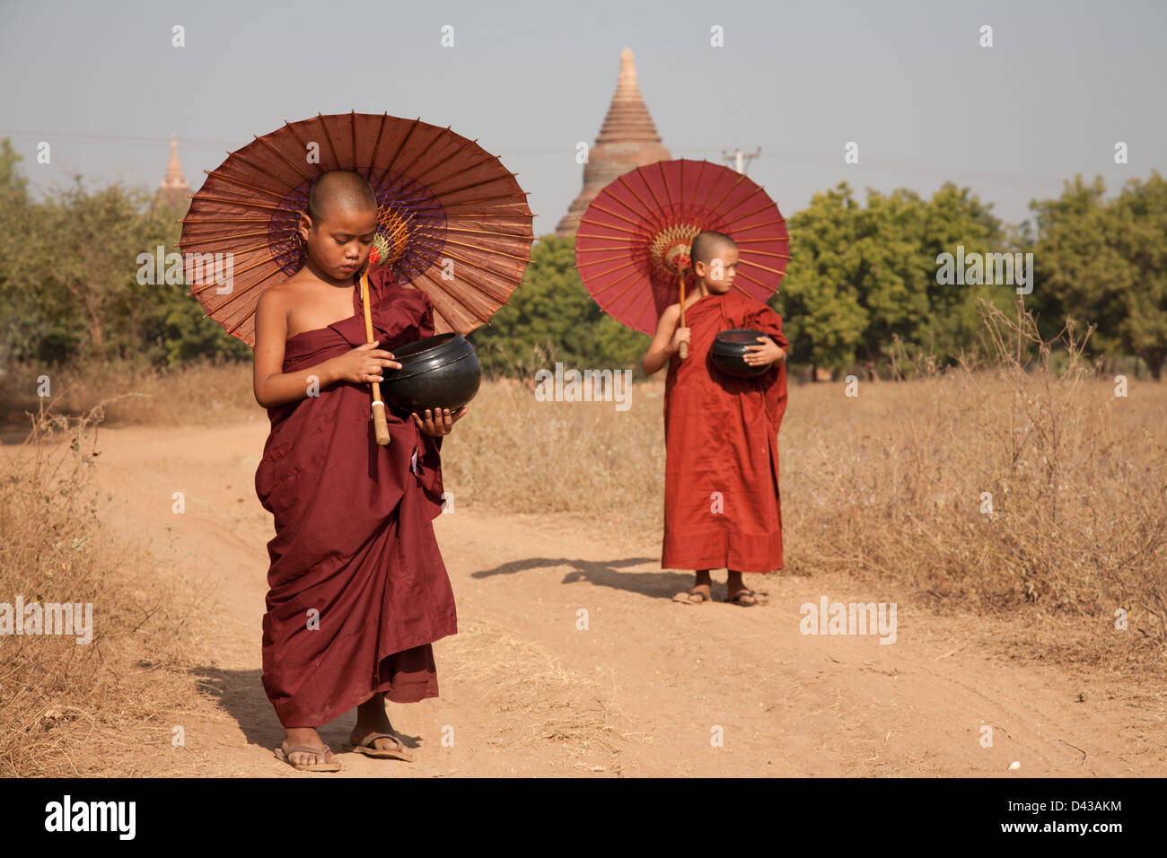 Two young Buddhist Monks resting on a path near Temples in Bagan Burma ...
