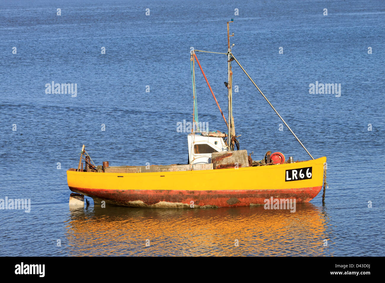 Small yellow inshore fishing boat anchored near the Stone Jetty in ...
