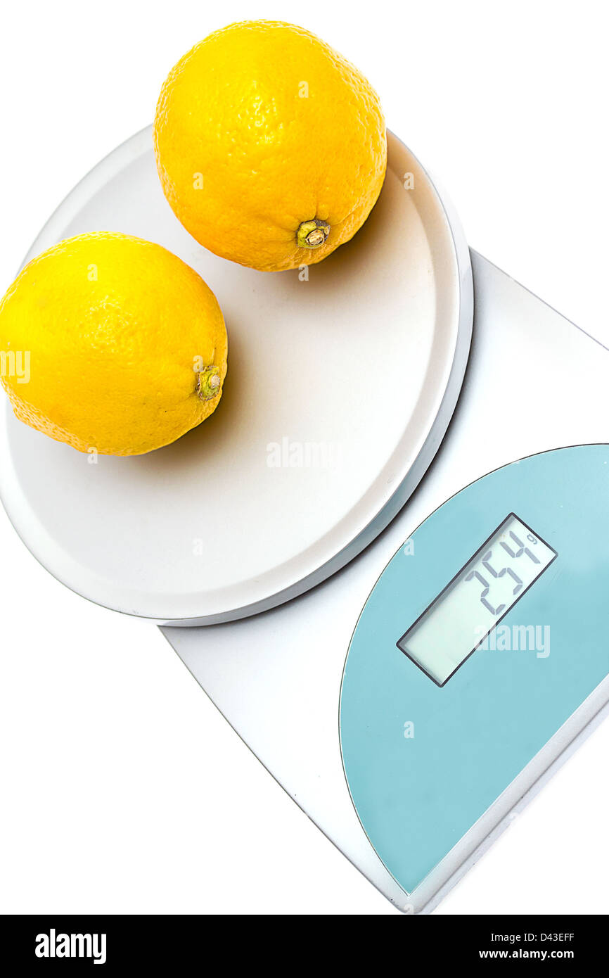 Lemons on the scales isolated on white Stock Photo - Alamy