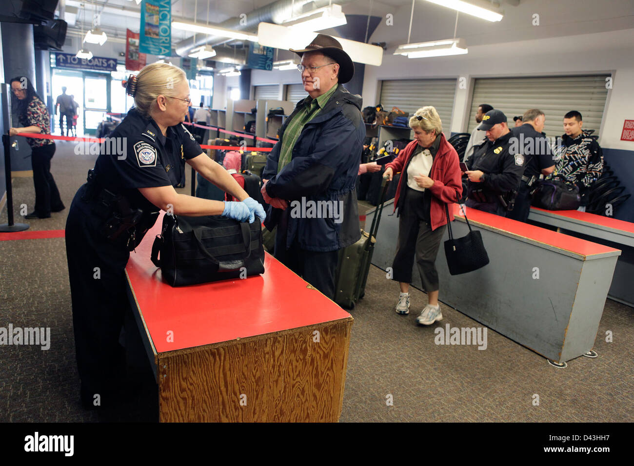 CBP officers conduct vehicle inspections at a U.S. port of entry using ...