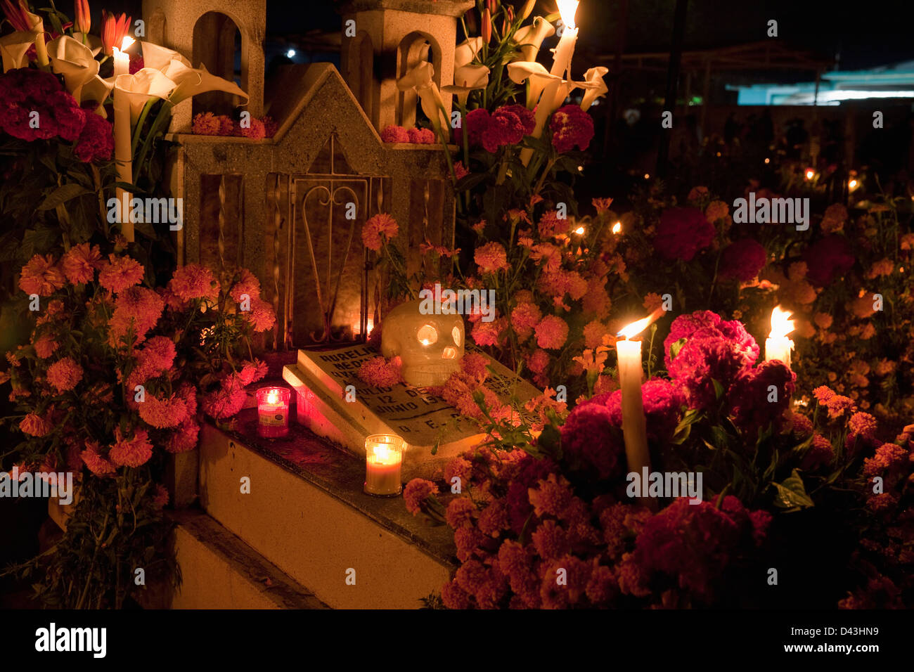 Grave decorated with candles, skull and flowers in celebration of Day ...