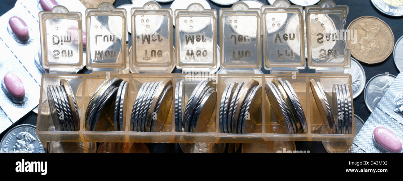 Coins in Pill Organizer Stock Photo - Alamy