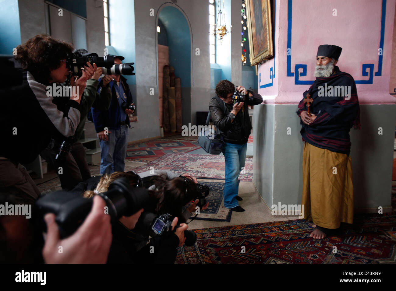 A group of photographers photographing an Ethiopian Orthodox monk at ...
