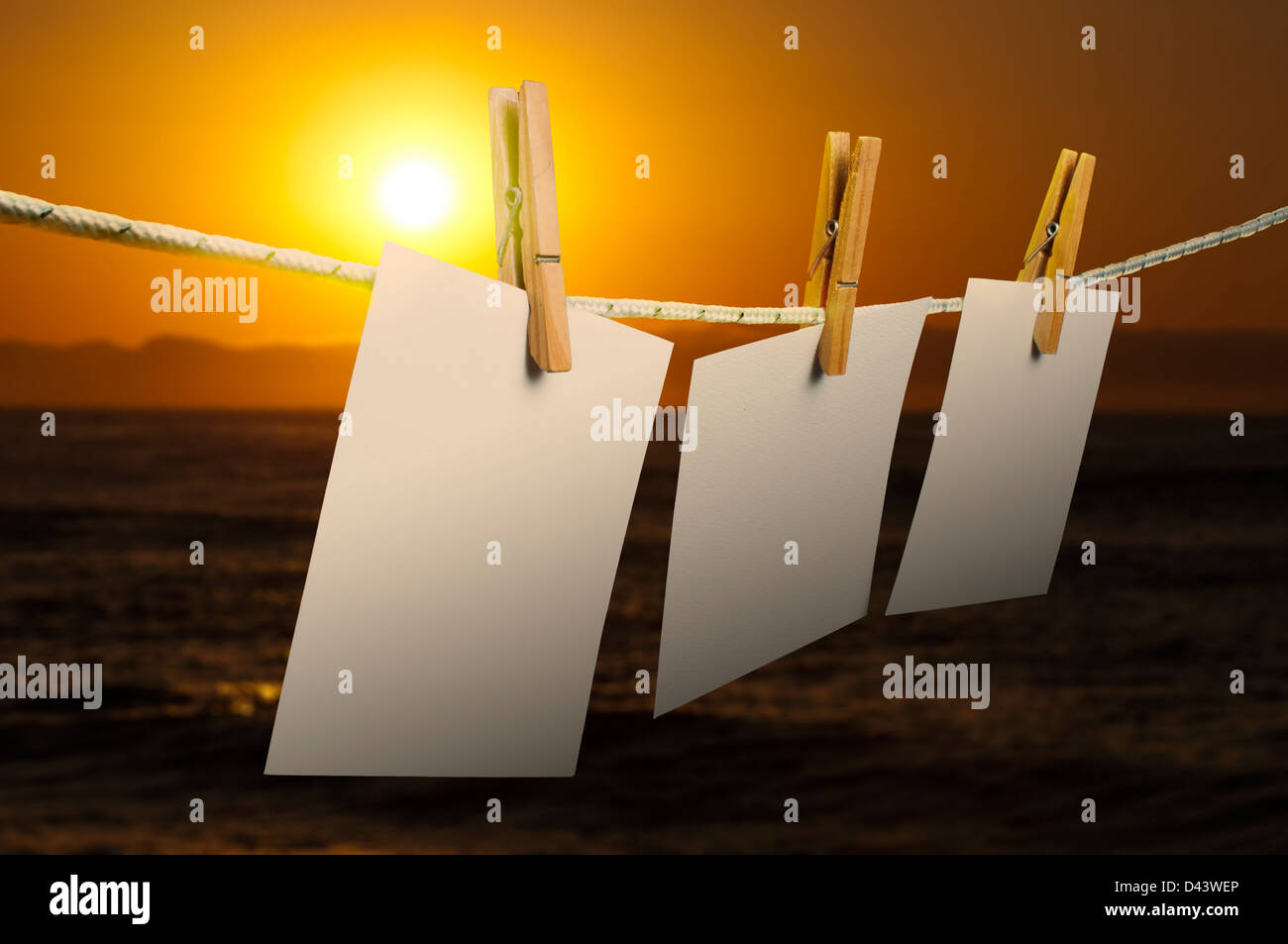 Note papers hooked on a rope. Sunset background Stock Photo - Alamy