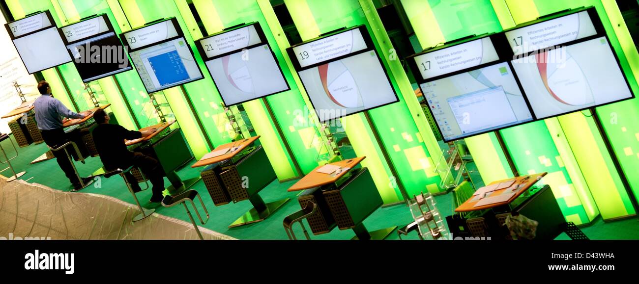 People work on computers at the Datev booth at the world's largest and ...