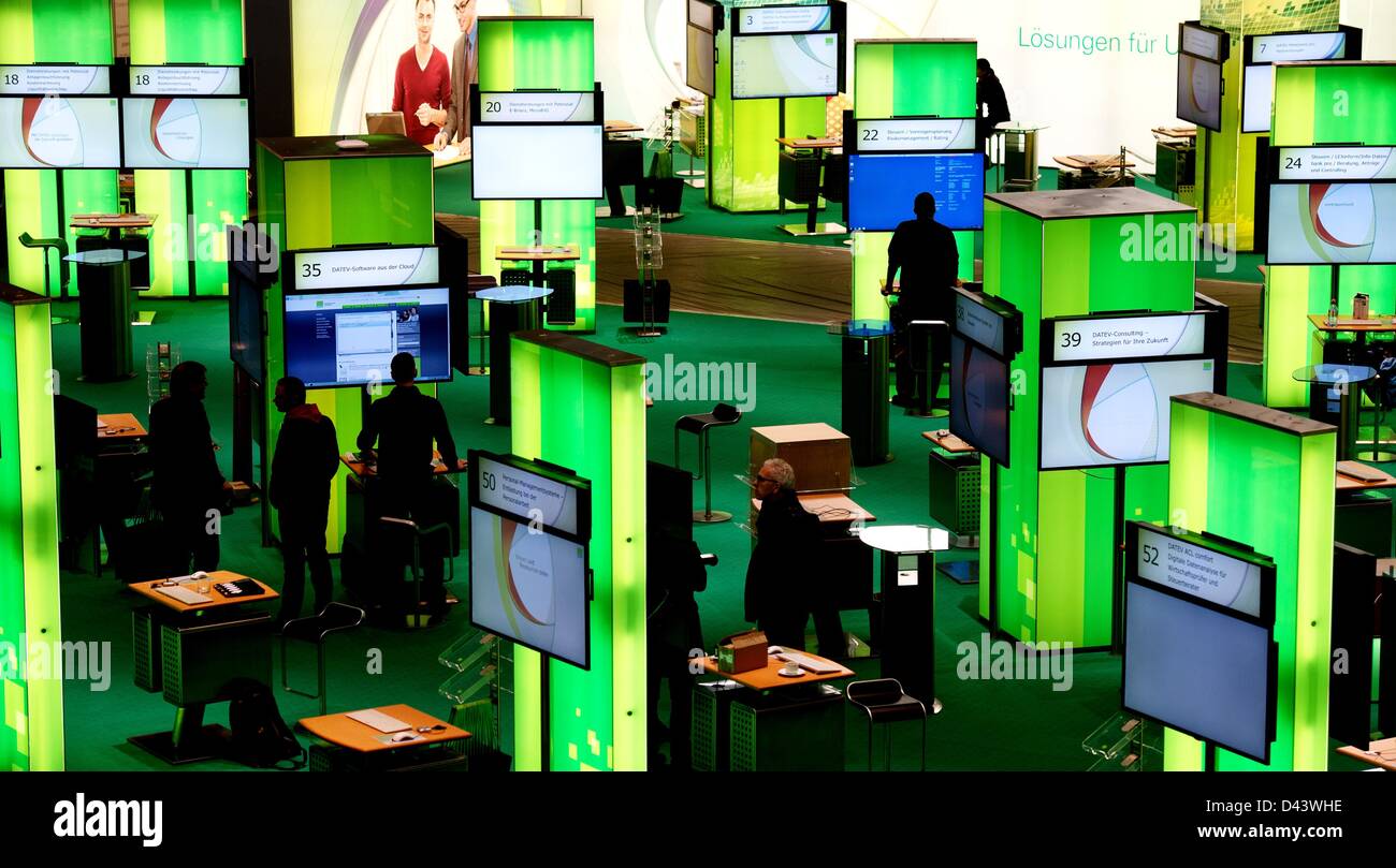 People work on computers at the Datev booth at the world's largest and ...