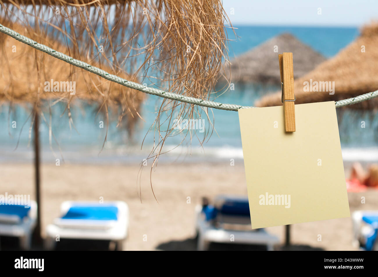 Note papers hooked on a rope. Beach background Stock Photo - Alamy