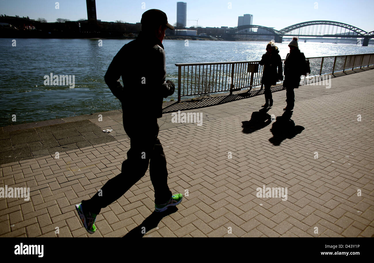 People enjopy the sunny weather on the banks of the Rhine river in ...