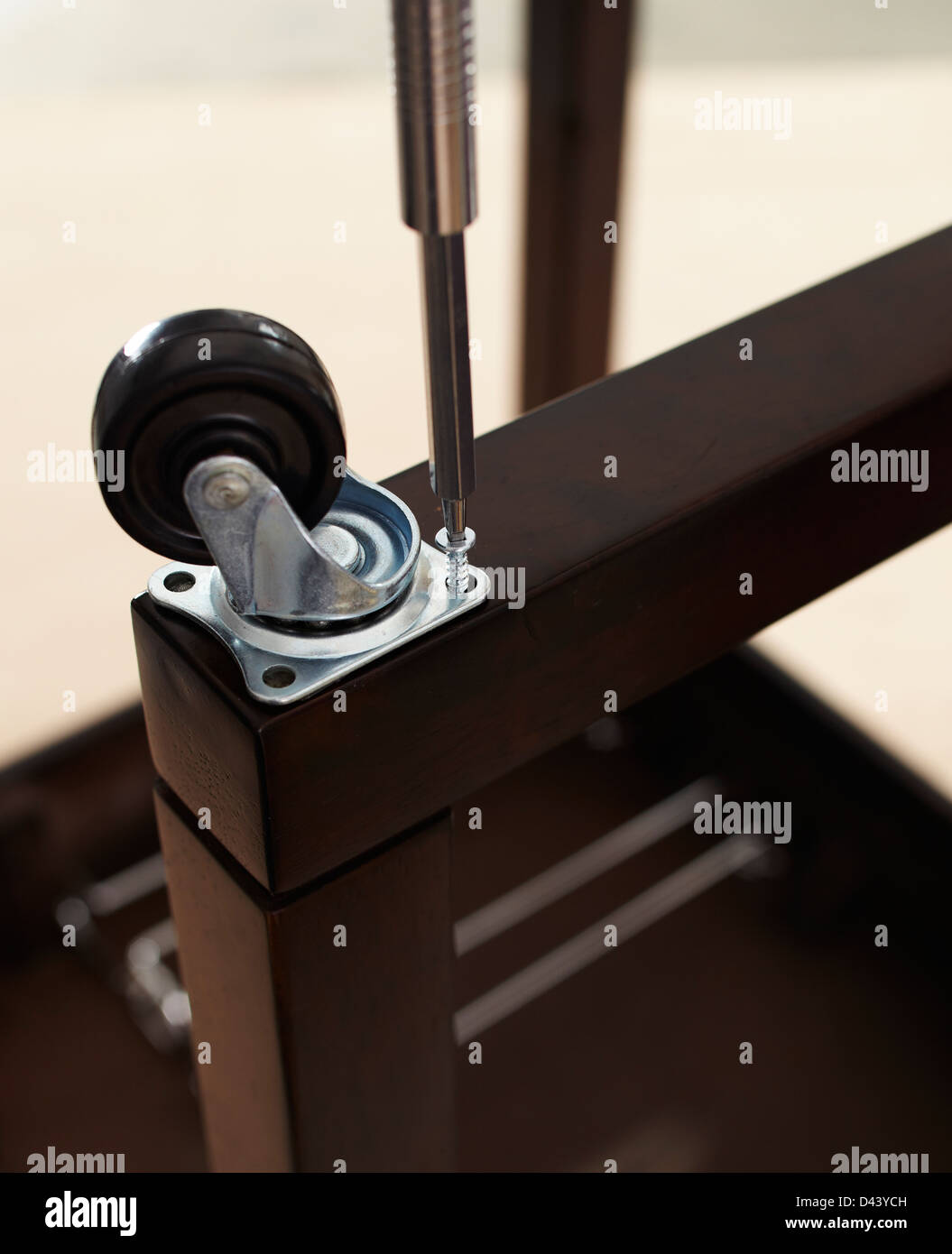 Close-up of Screwdriver Attaching Caster Wheel to Table Stock Photo - Alamy