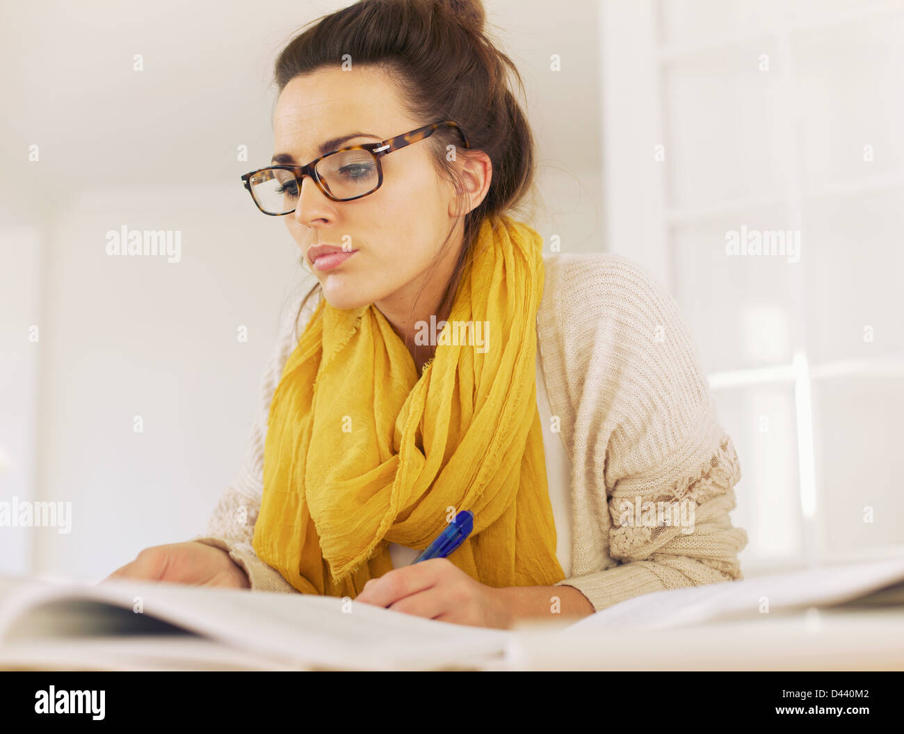 Busy woman reading her textbook and taking down notes Stock Photo - Alamy