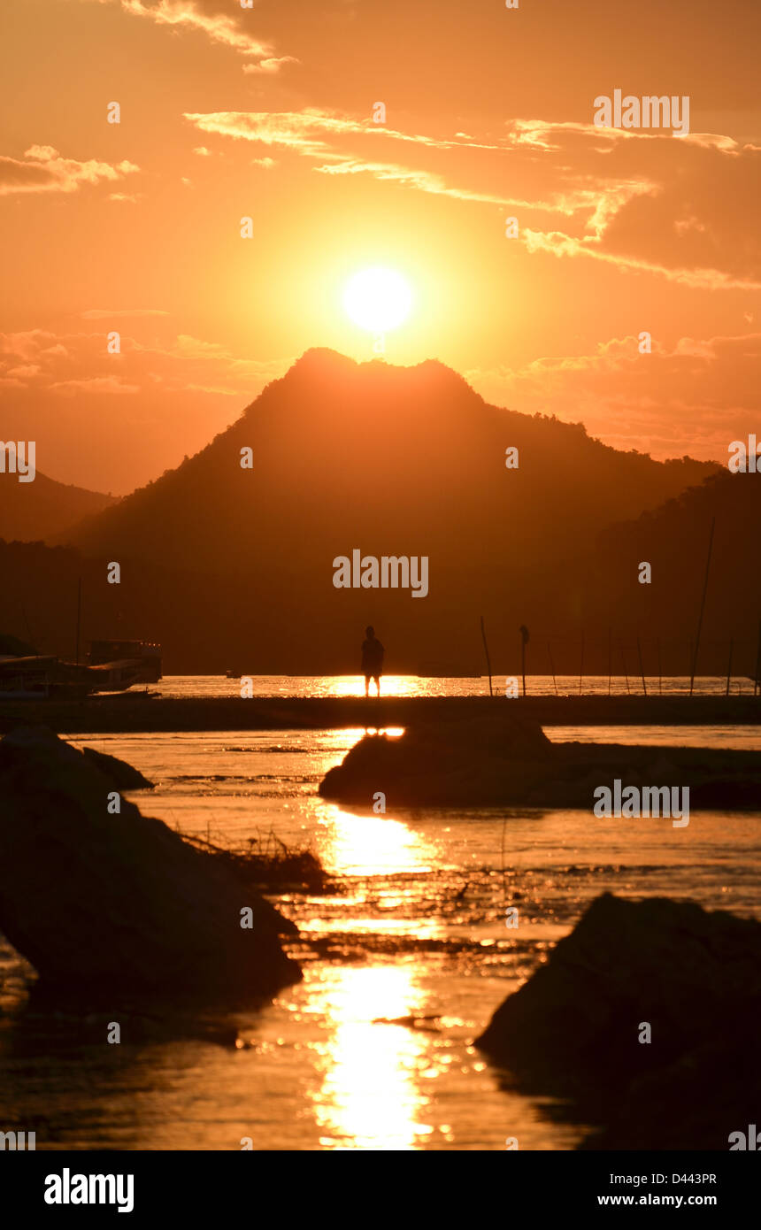 Silhouette of man against sunset on the Mekong River, Luang Prabang ...