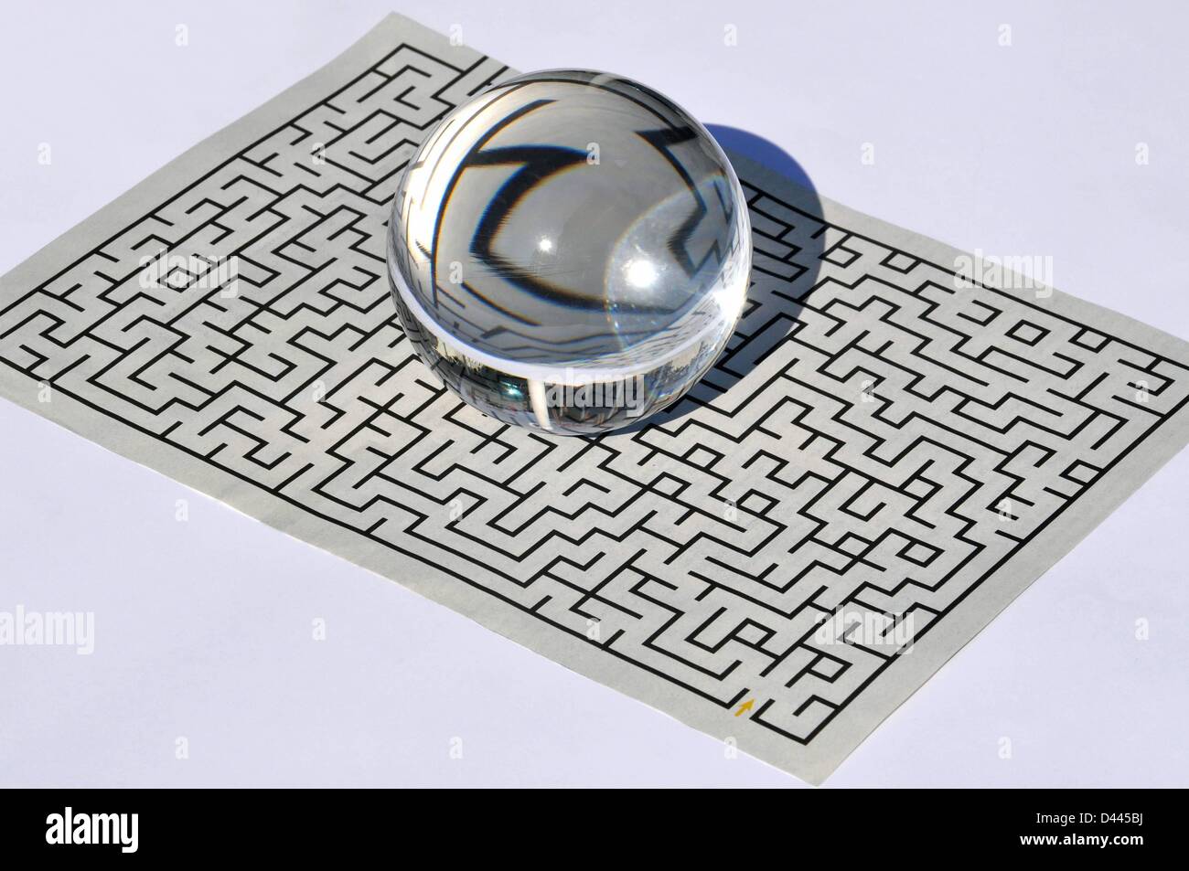 Illustration - A glass ball lies on a labyrinth printed on paper on 10 ...