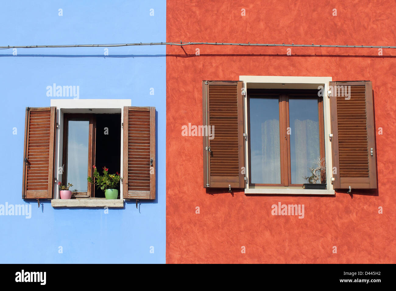 two windows with shutters on colorful wall Stock Photo - Alamy