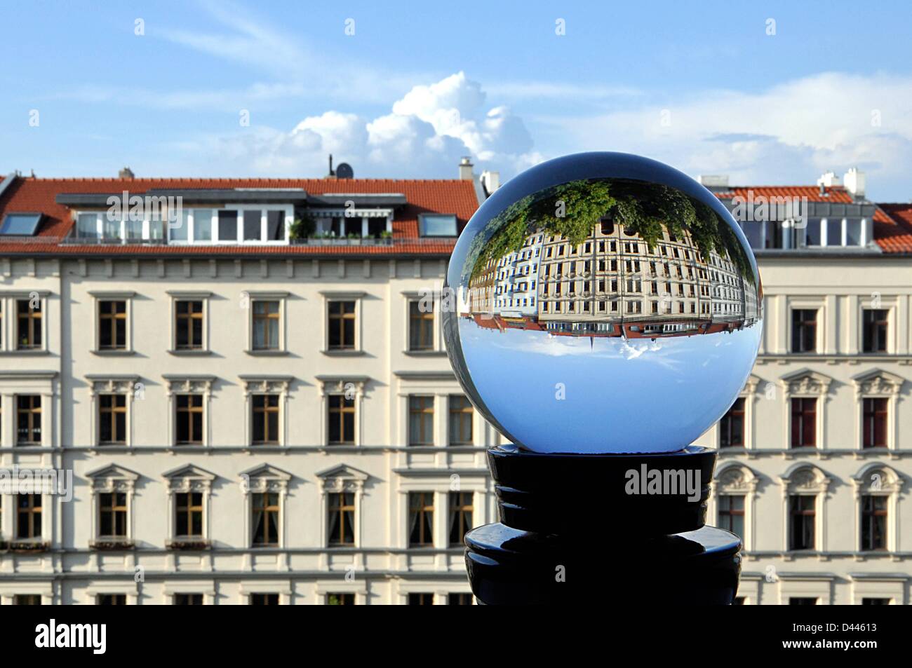 A renovated residential building is reflected in a glass ball in the ...