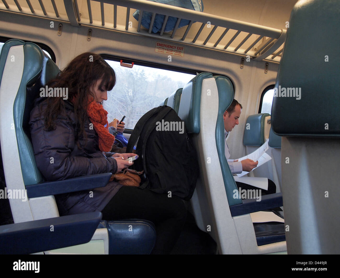 Commuter train passengers using Smartphones and reading papers, New ...