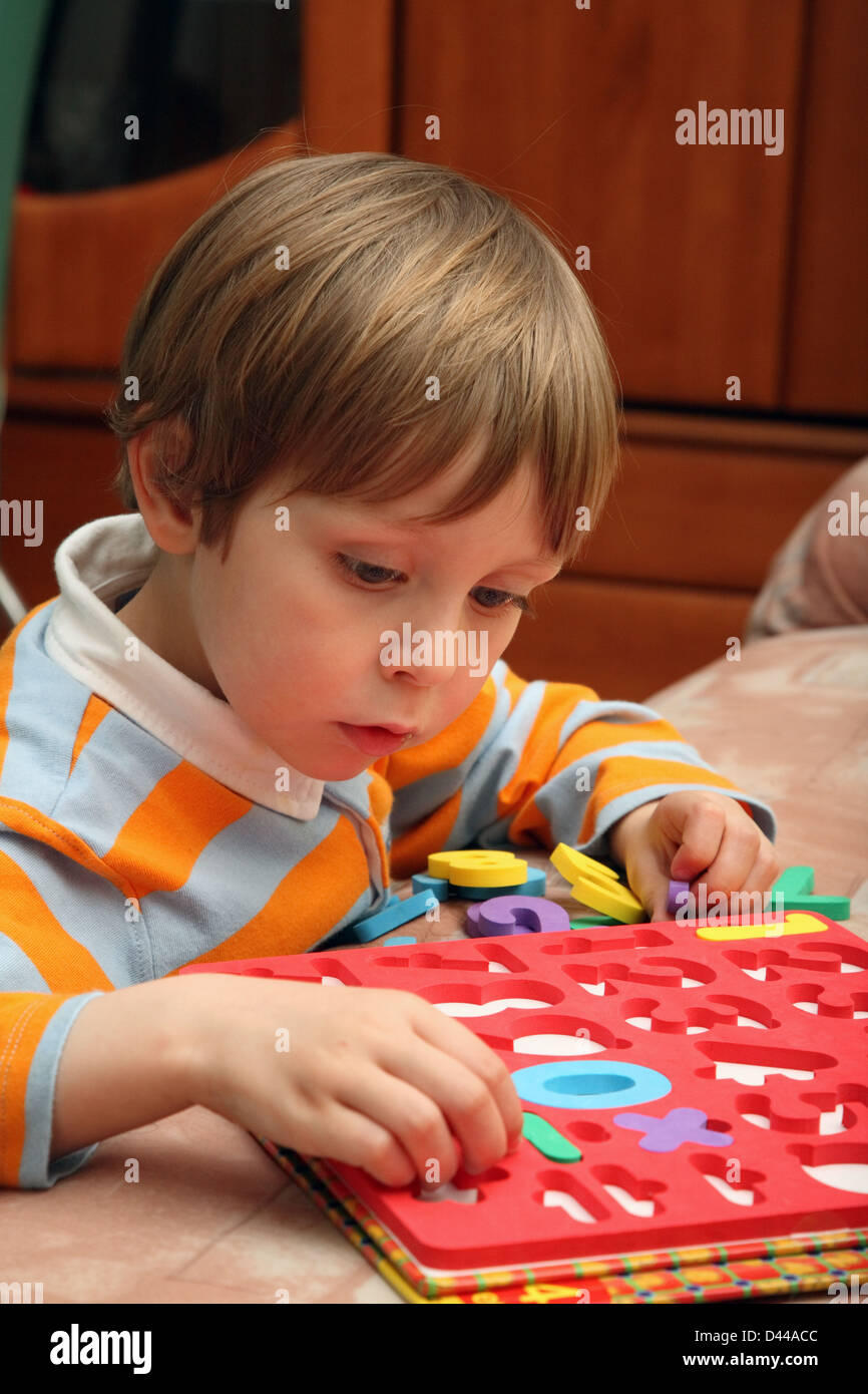 Young boy playing with plastic numbers Stock Photo - Alamy