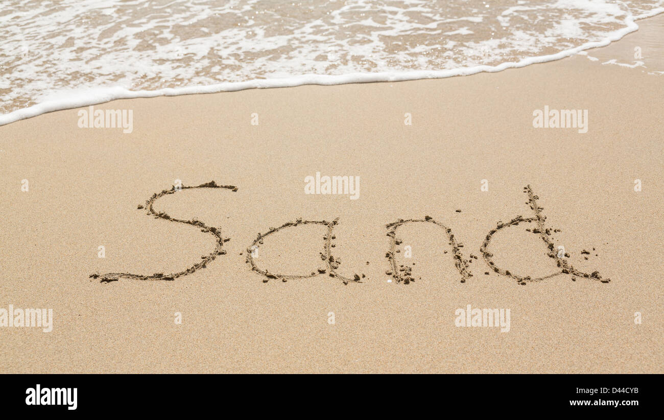 'Sand' drawn on a tropical beach Stock Photo - Alamy