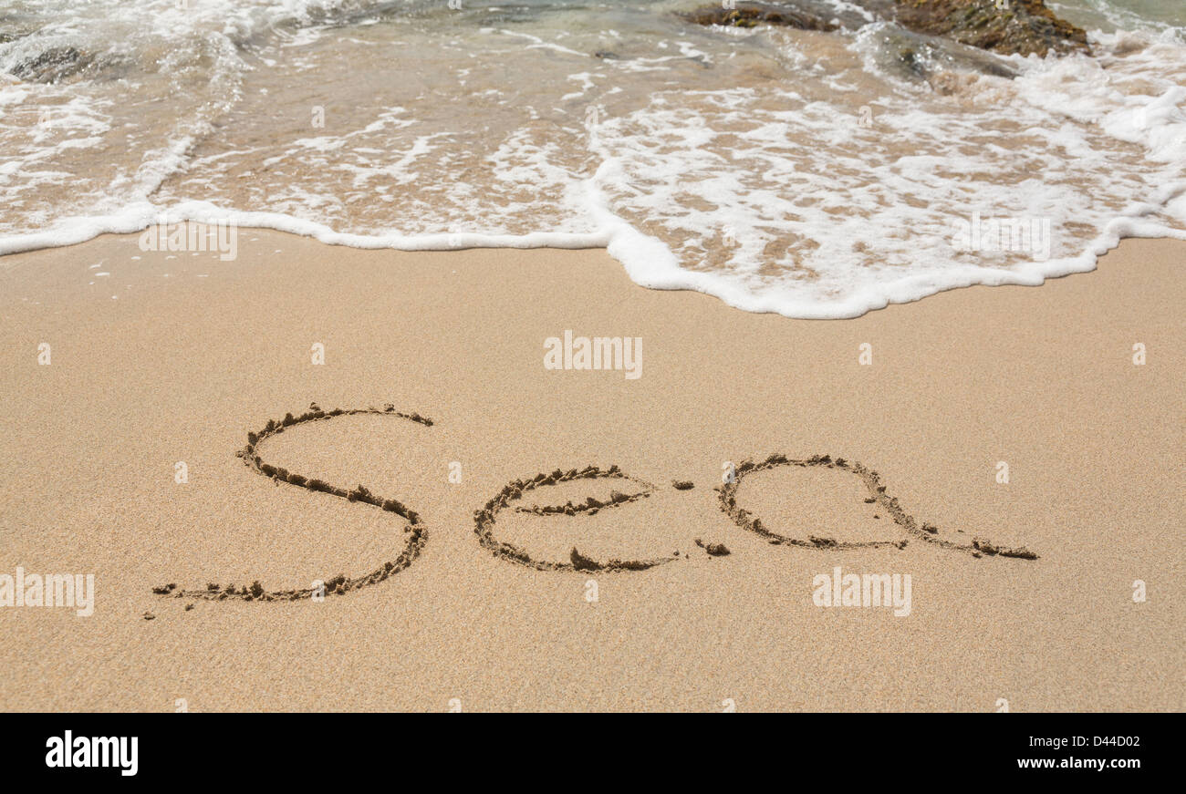 The word Sea drawn in the sand on a tropical beach Stock Photo - Alamy