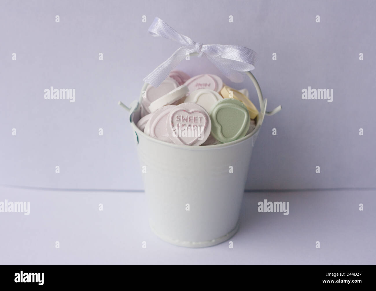 Little white bucket full of love heart sweets Stock Photo - Alamy