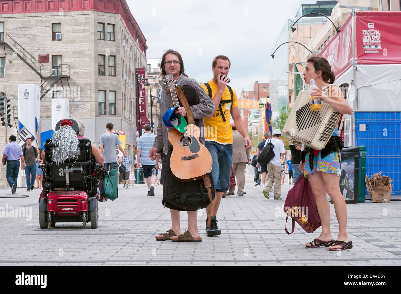 Musicians carrying their instruments across Ste-Catherine street during ...