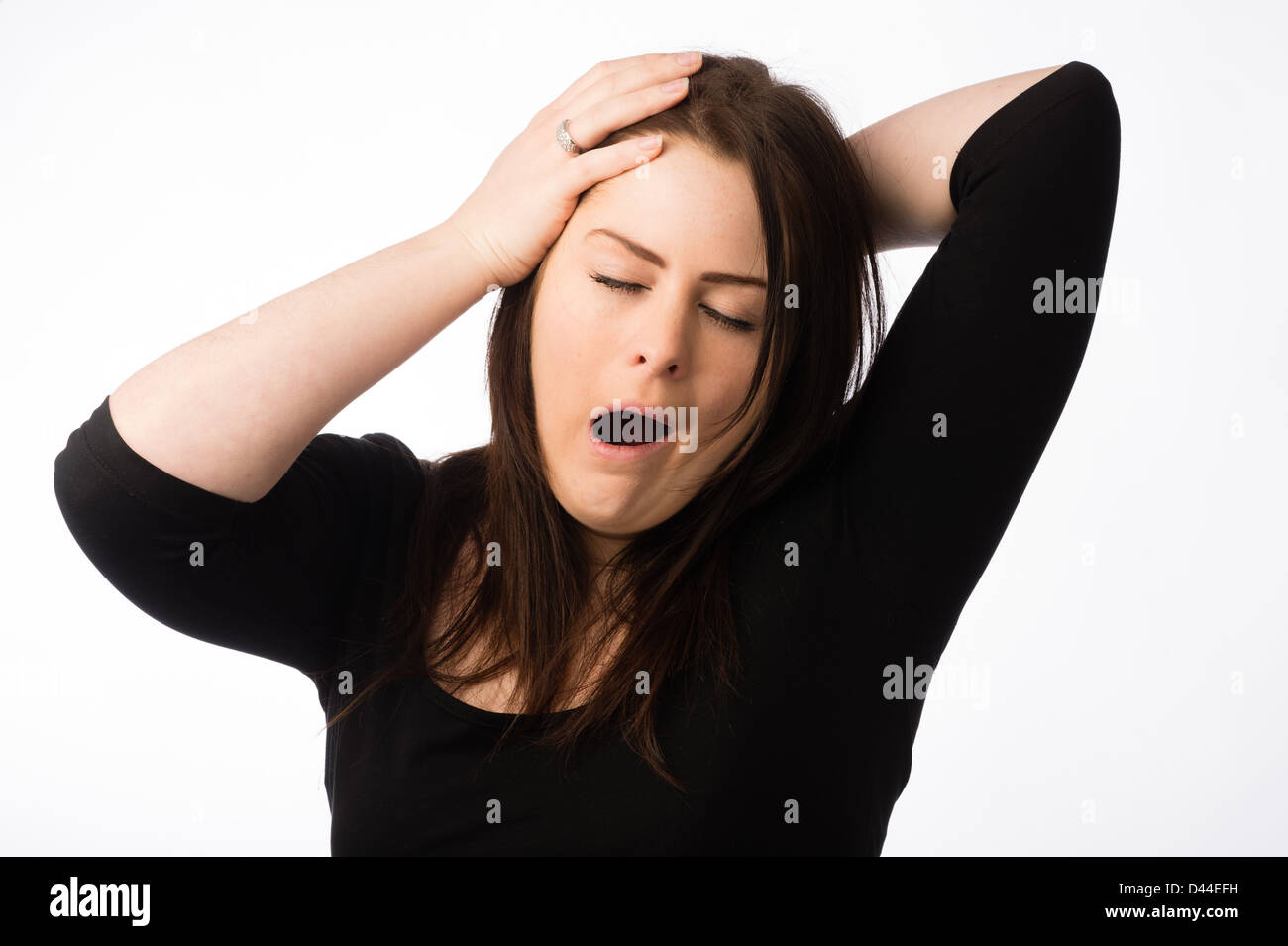 A young tired sleepy yawning woman, brown hair, UK Stock Photo - Alamy