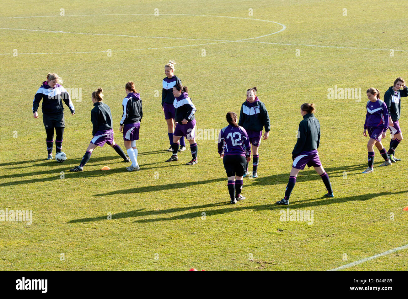 University sport, women`s footballers doing warm-up exercises before ...