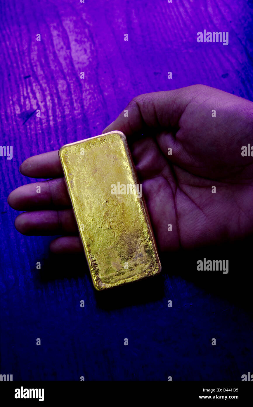 Hand held gold bar Stock Photo - Alamy