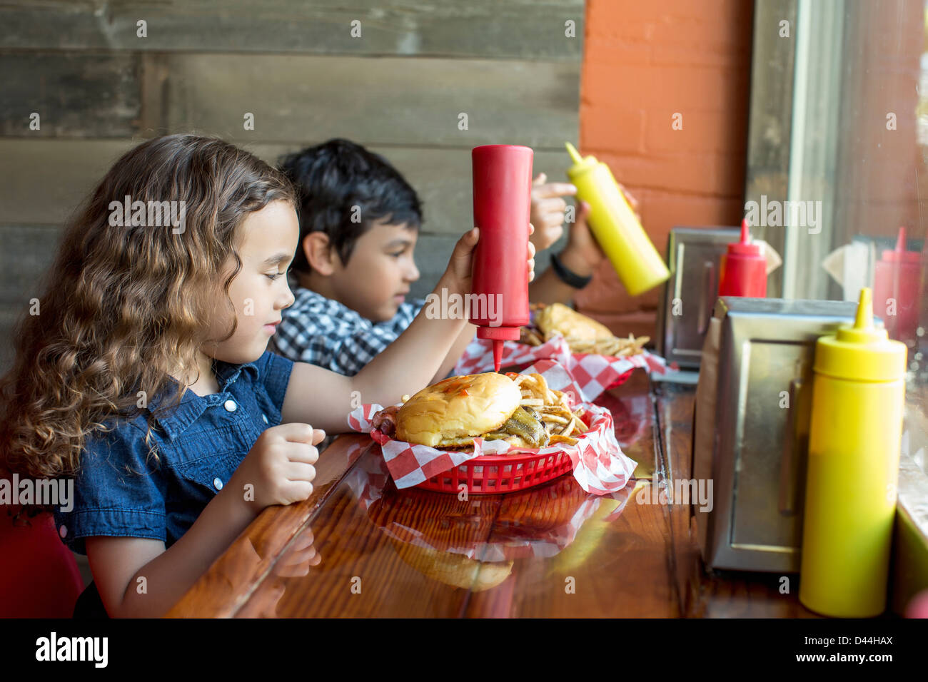 Mixed race children having burgers in restaurant Stock Photo - Alamy