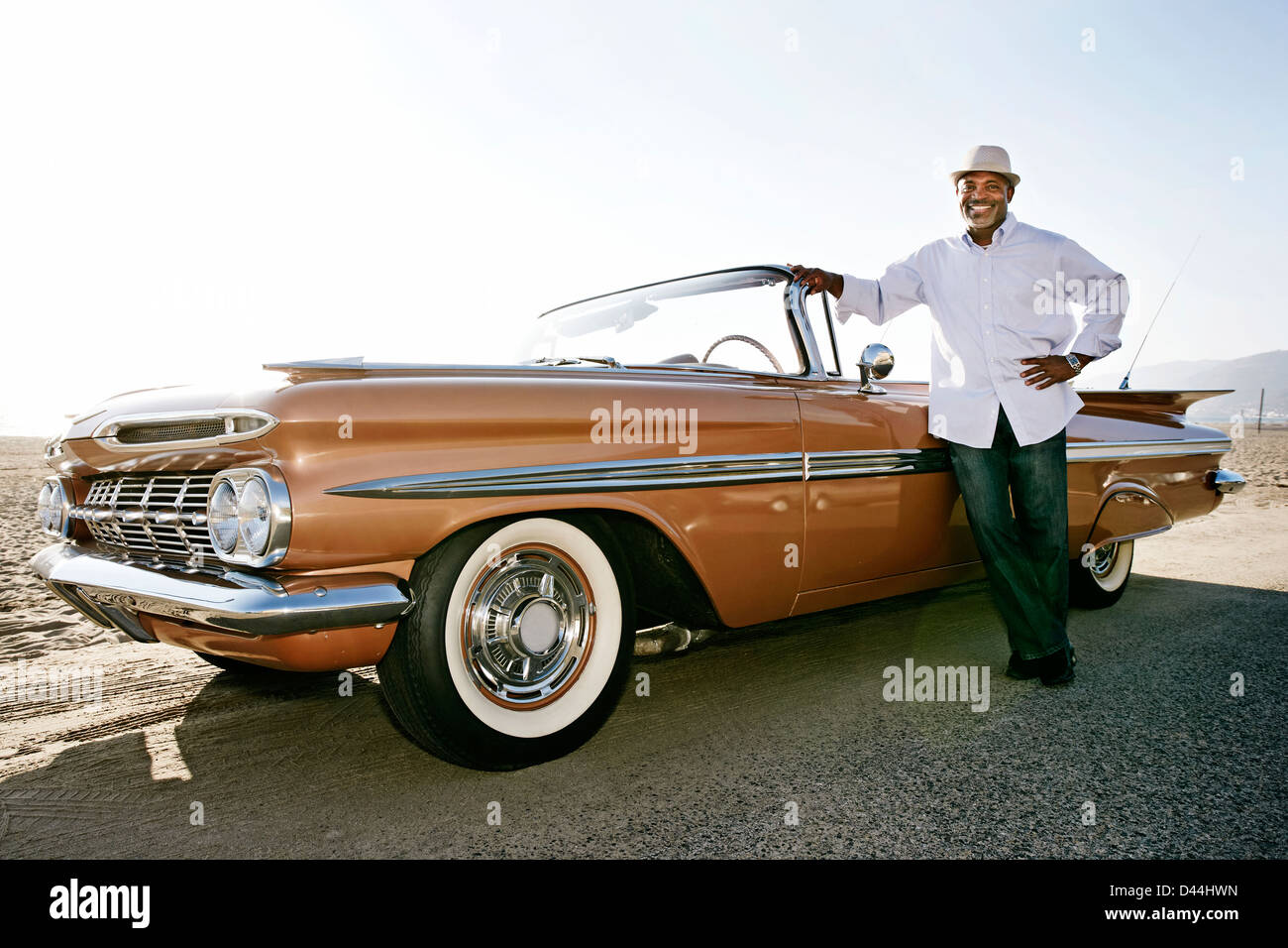 Black man leaning on convertible Stock Photo - Alamy