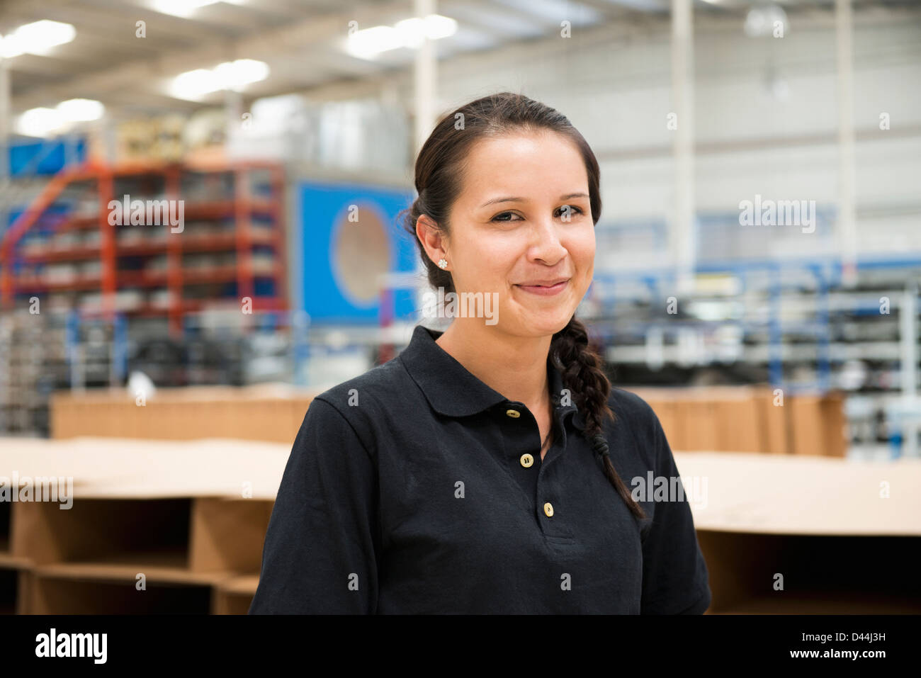 Worker smiling in manufacturing plant Stock Photo - Alamy