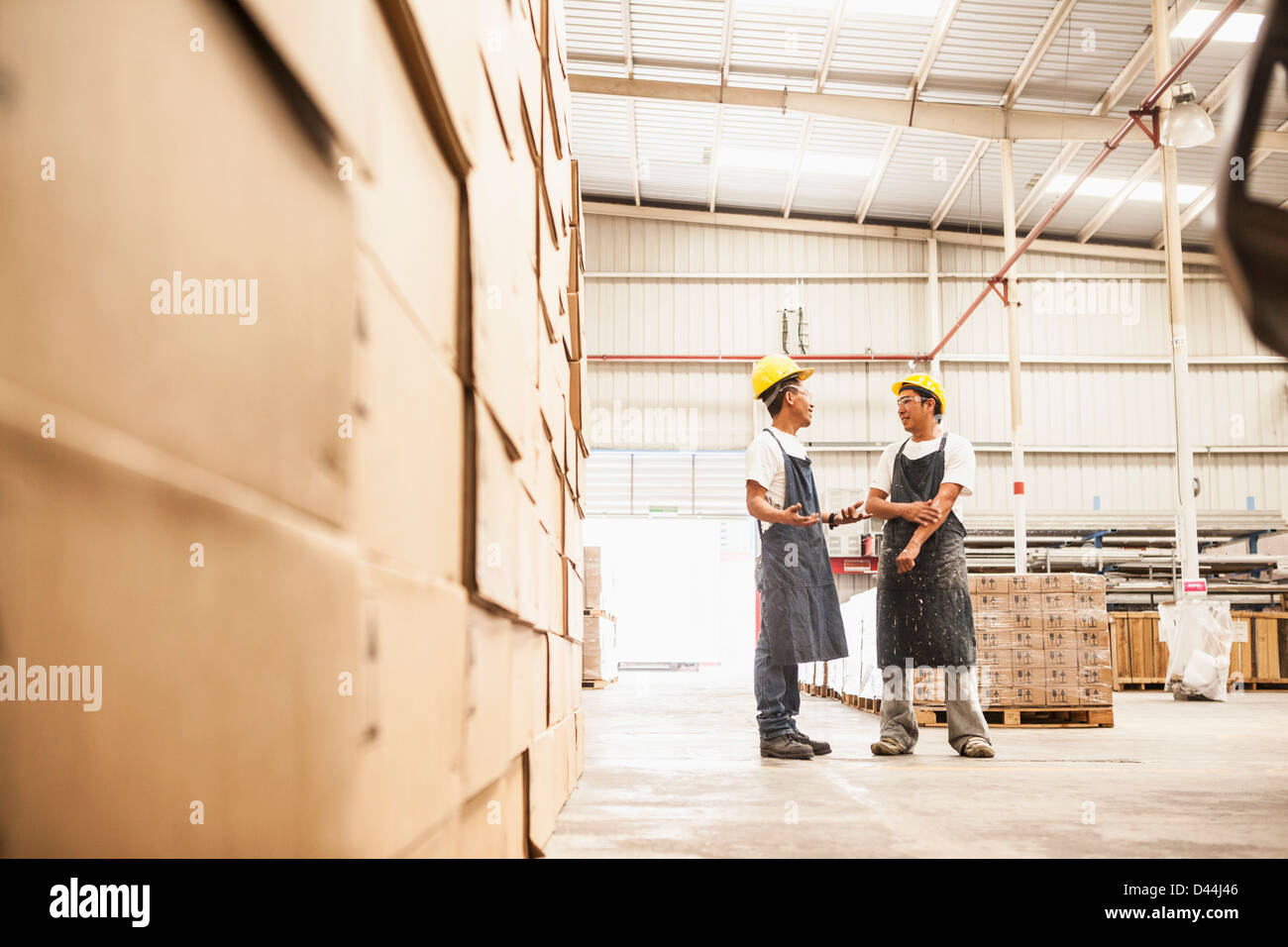 Workers talking in manufacturing plant Stock Photo - Alamy
