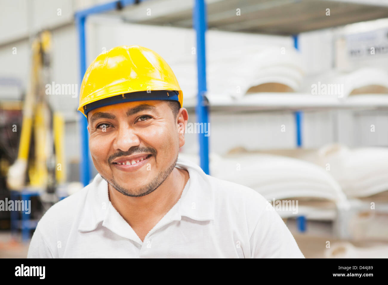 Worker smiling in manufacturing plant Stock Photo - Alamy