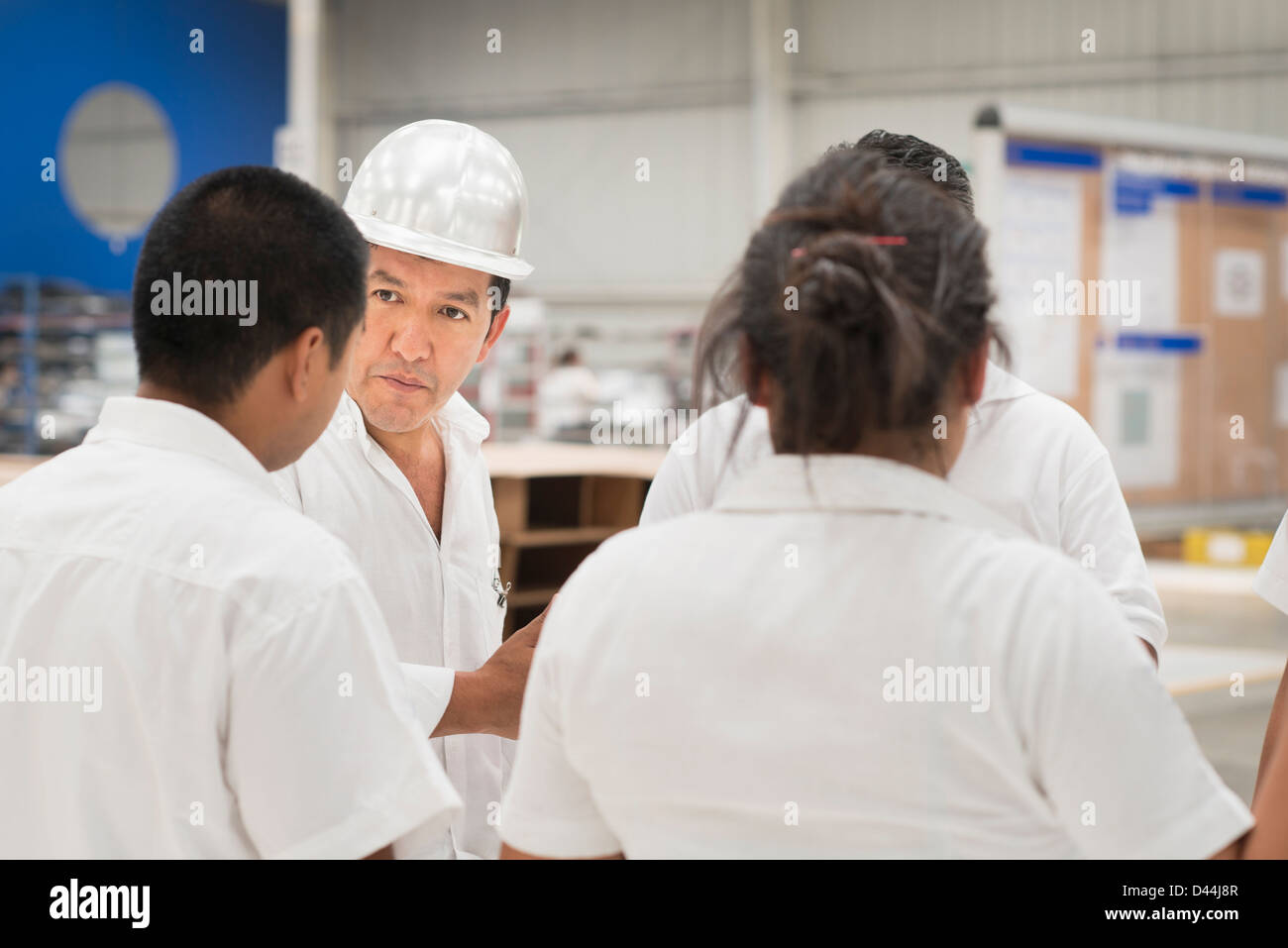 Workers talking in manufacturing plant Stock Photo - Alamy