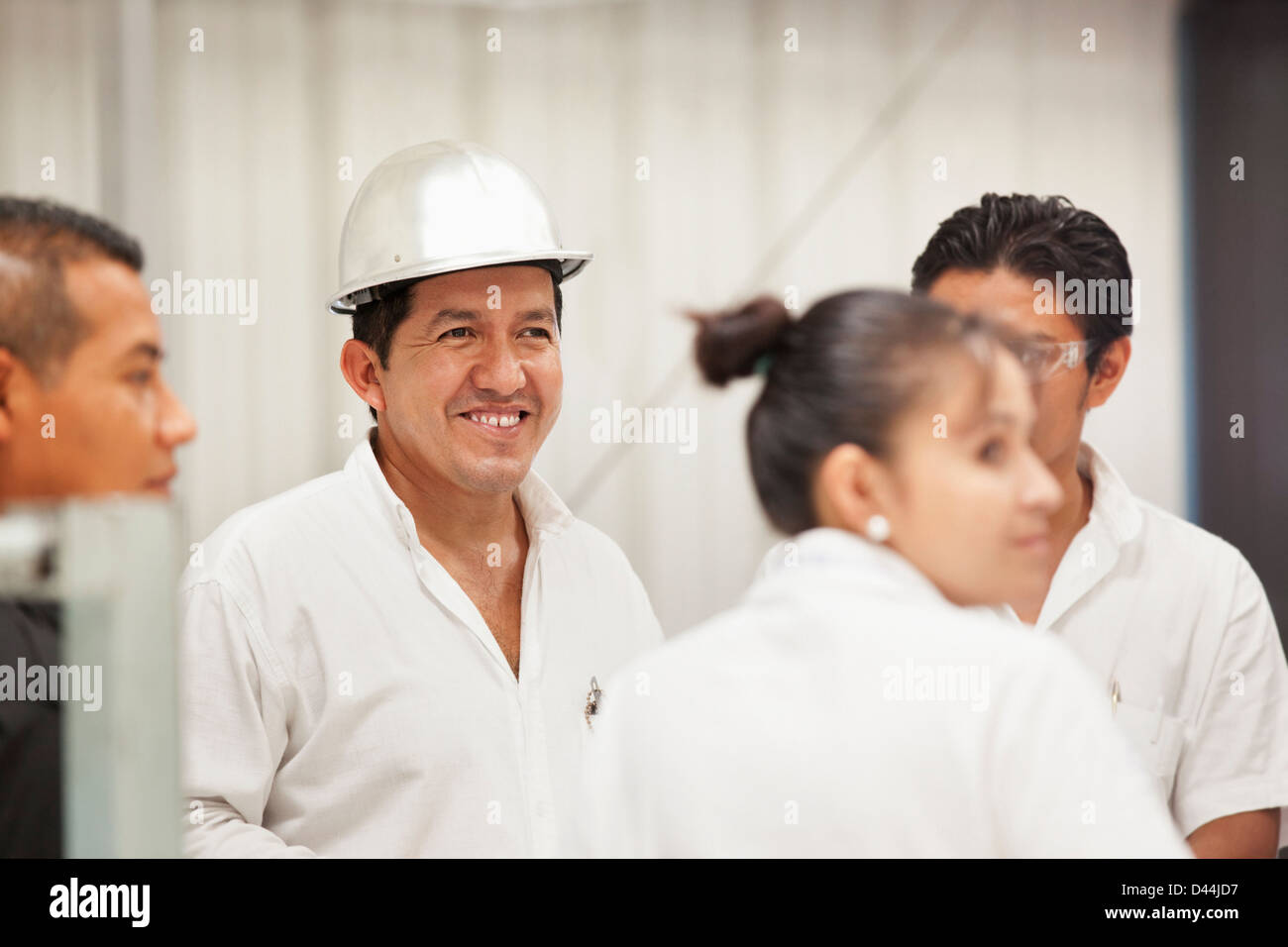 Worker smiling in manufacturing plant Stock Photo - Alamy