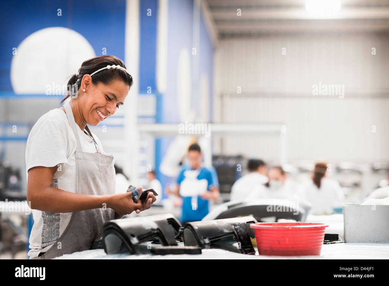 Worker smiling in manufacturing plant Stock Photo - Alamy