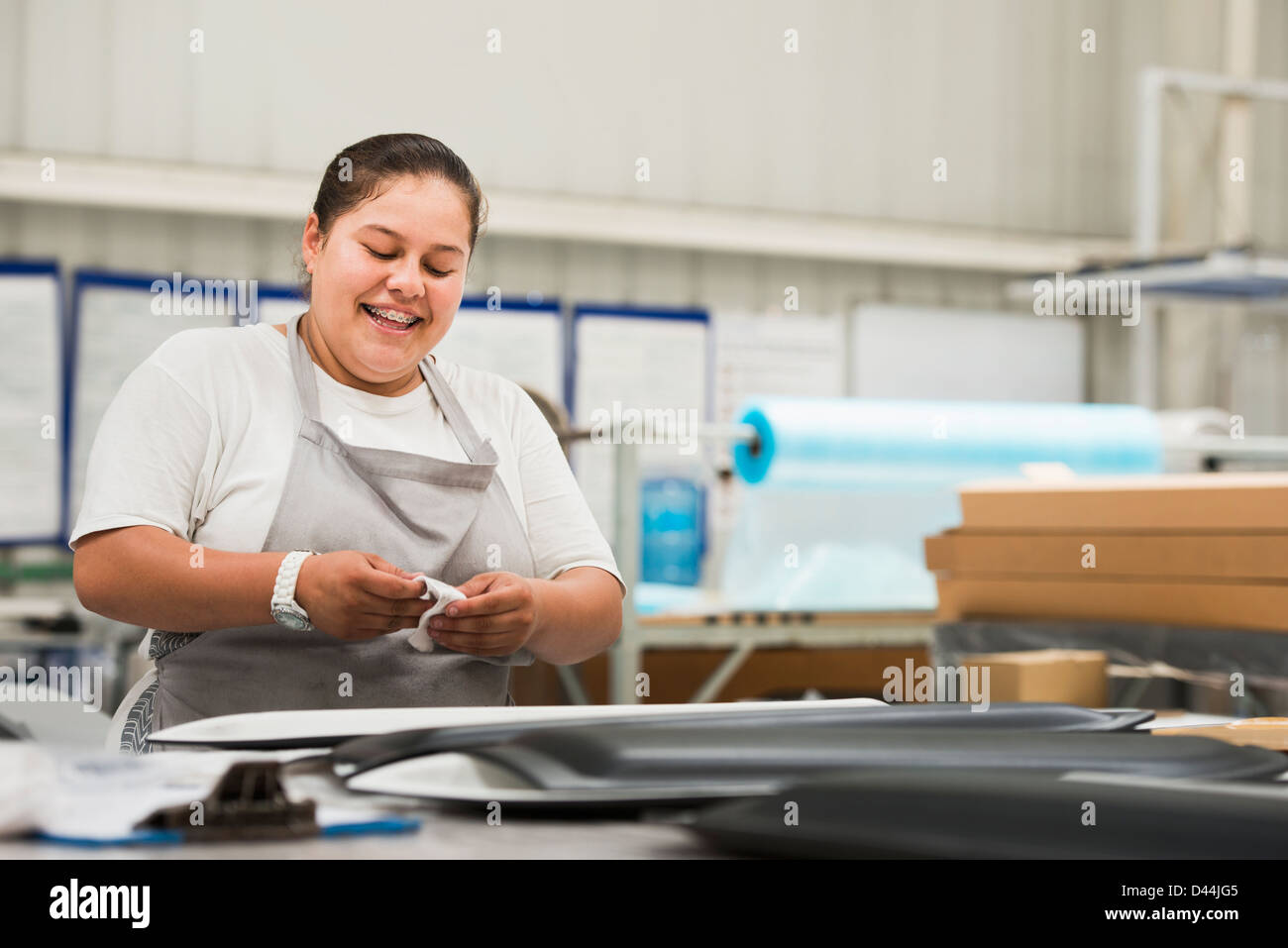 Worker smiling in manufacturing plant Stock Photo - Alamy