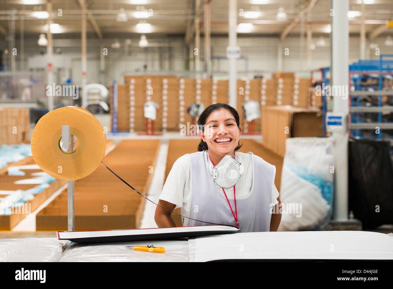Worker smiling in manufacturing plant Stock Photo - Alamy