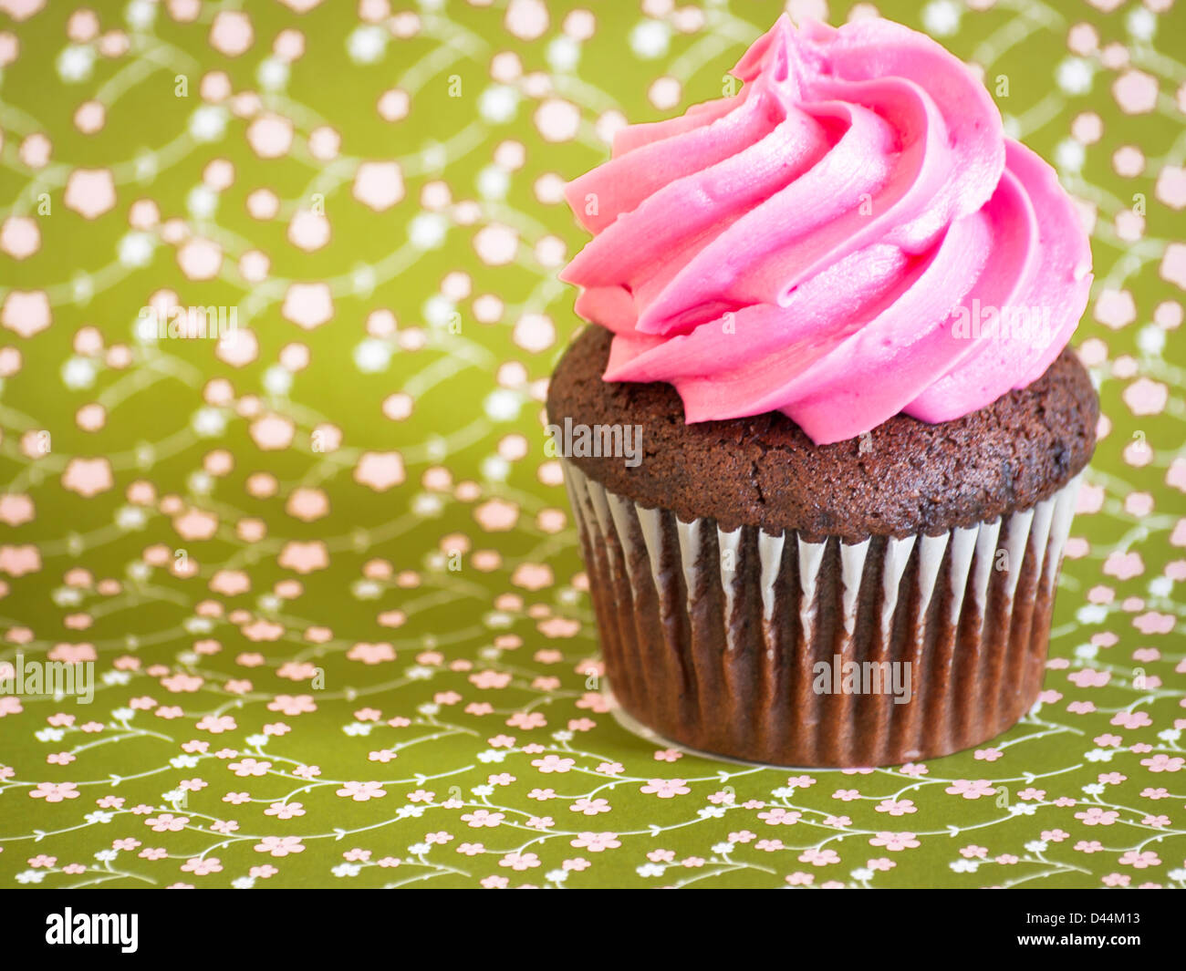 Pink cupcake on a green background Stock Photo - Alamy