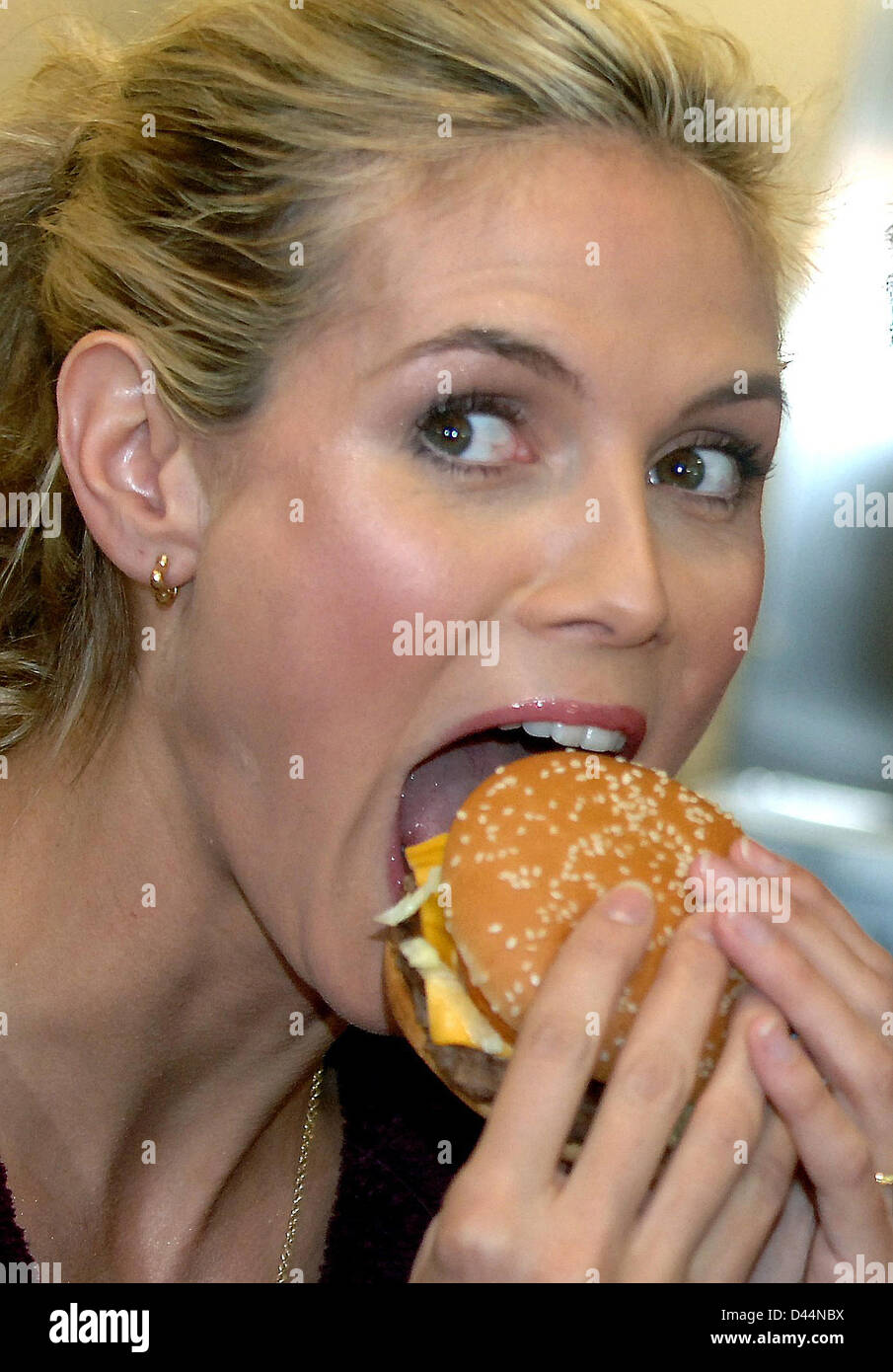 (dpa) - Supermodel Heidi Klum bites into a hamburger at a McDonald's ...