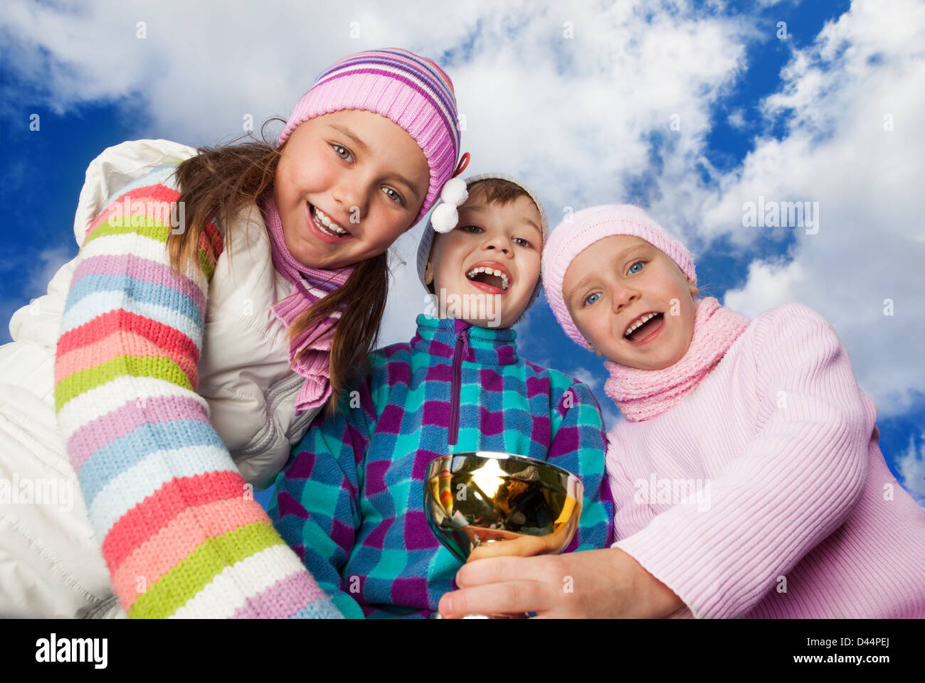 three happy friends with award on sky background Stock Photo - Alamy