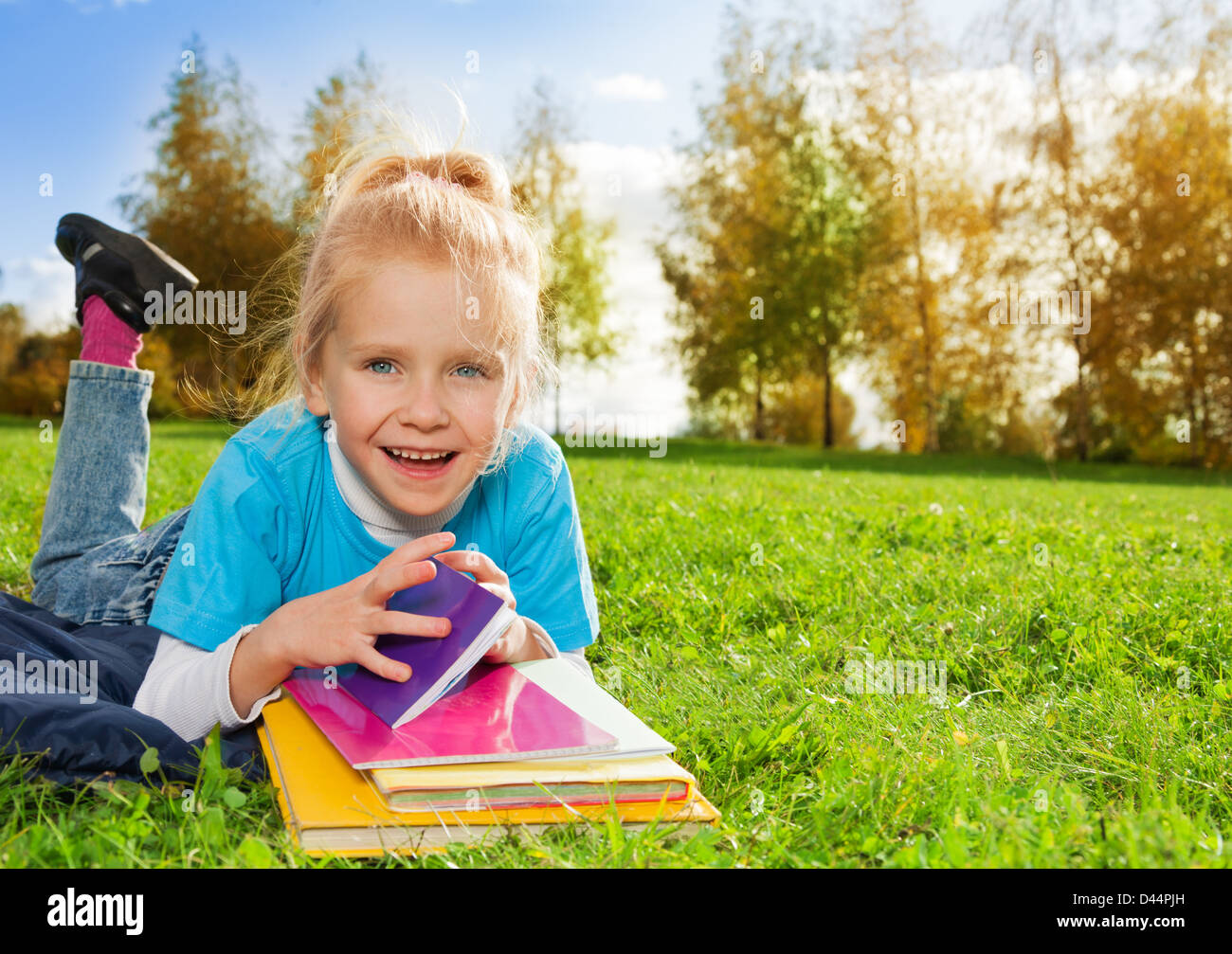 laughing little girl with books in park Stock Photo - Alamy
