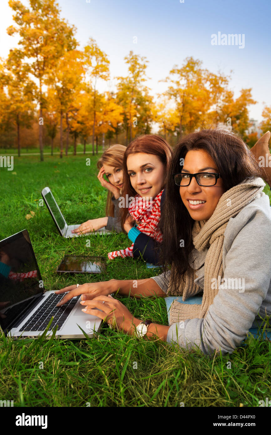 Friends using wi-fi internet in sunny park Stock Photo - Alamy