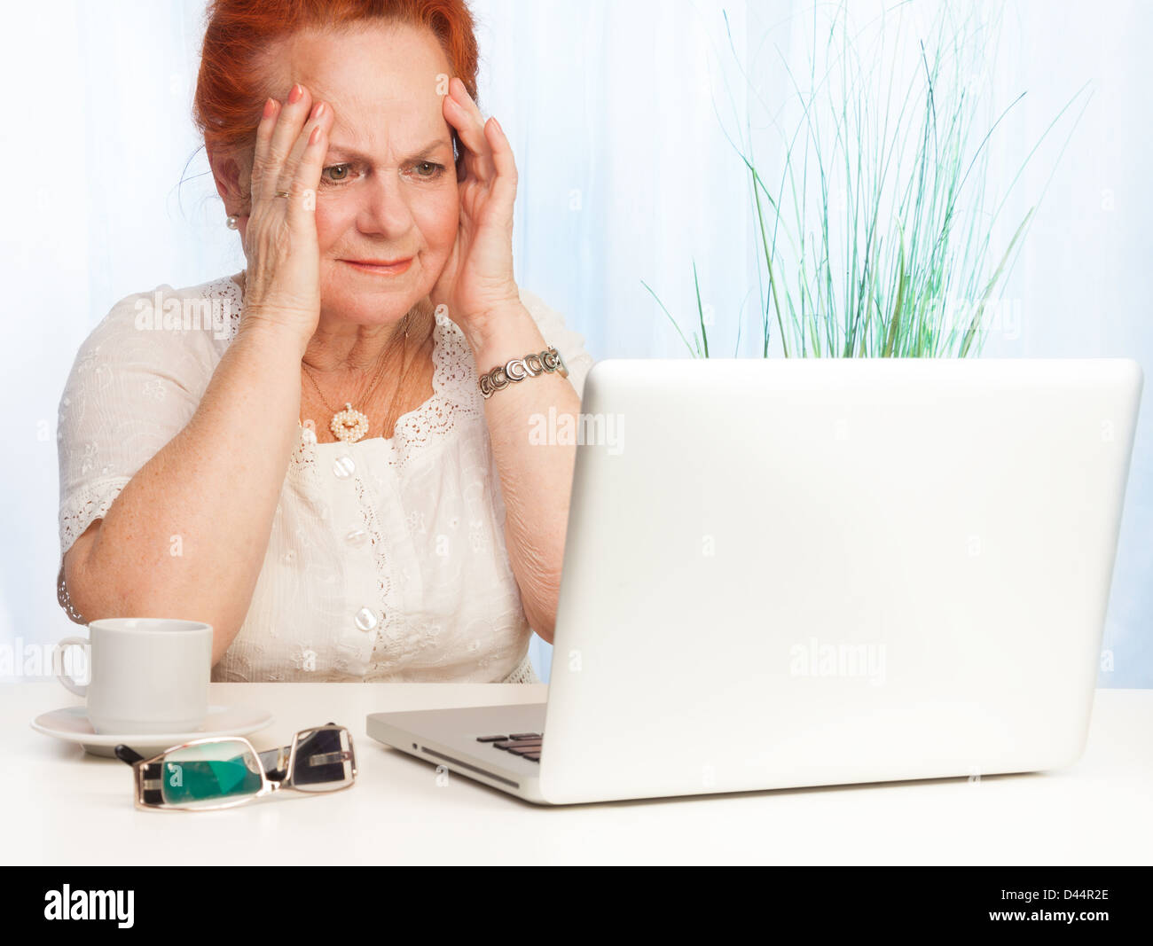 Senior woman with confused expression on her face sitting behind her ...